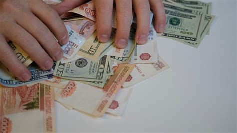 탐욕 뇌물 수수 및 부패 남성의 손은 긁어 러시아와 미국의 지폐에서 돈의 무리를 당기고있다 5천 루블 지폐에 대한 스톡 사진 및