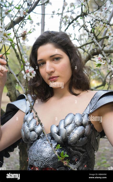 Garden Beautiful Brunette Girl Dressed In Armor In A Grove Of Cherry