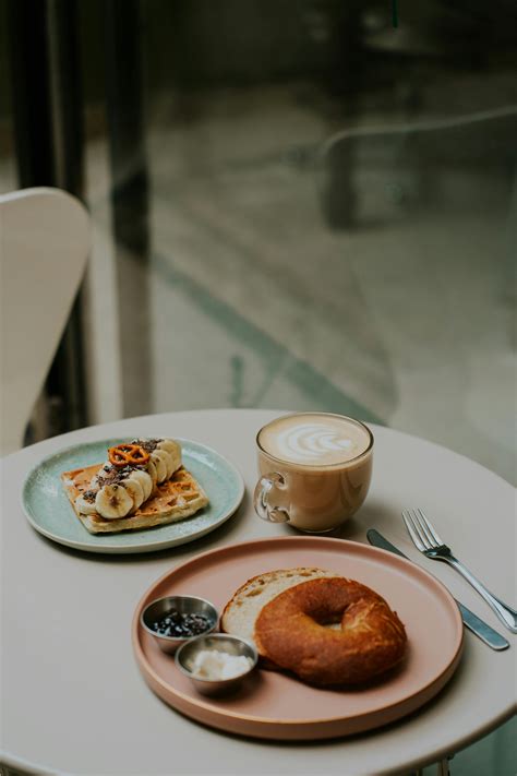 실내 가벼운 갈라지다 낮 뉴트럴 톤 달콤한 둥근 판 디저트 따뜻한 라떼 라떼 아트 라즈베리 레스토랑 막대기 미니멀리스트 미식가 바나나