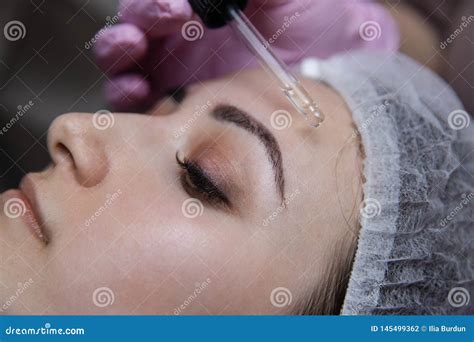Yong Pretty Girl With Bright Brows In Process Of Applying Hyaluronic Acid On Her Face Stockfoto