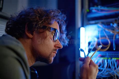 Closeup Face Of Male Network Engineer Connecting Cables In Server Room Stock Image Image Of