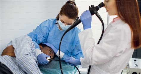 현대 클리닉에서 내시경 검사를 받는 아프리카 남성 환자 섬유위십이지장경 검사 절차를 수행하는 두 명의 전문 여성 백인 의사 사진 Unsplash의 병원 이미지