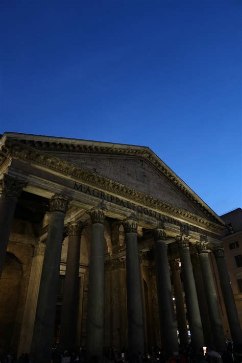 a very tall building with many columns and a sky background photo free İtalya image on unsplash