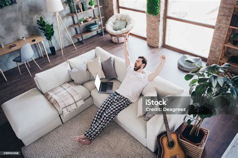 잠옷을 입고 졸린 멋진 남자가 부드러운 Divan 손을 들고 앉아 주말 휴가 로프트 인테리어 실내 40 44세에 대한 스톡 사진 및 기타 이미지 Istock