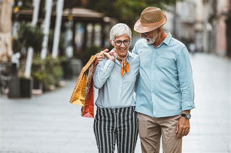 잘 생긴 수석 남자와 그의 아름 다운 아내 에 The City 거리 와 종이 가방 2명에 대한 스톡 사진 및 기타 이미지 2명 60 69세 Store Opening