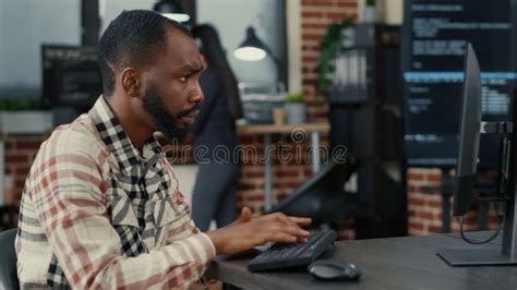 Tripod Shot Of African American Cloud Programer Writing Code Focused Looking At Computer Screen