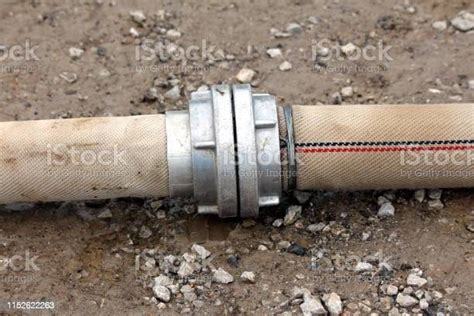 심하게 사용 되는 큰 직경의 소방 호스는 두꺼운 금속 연결과 연결 하 고 자갈로 둘러싸인 뒤뜰에서 홍수 물을 펌핑 하는 데 사용 되는 전선으로 강화 되었습니다 0명에 대한