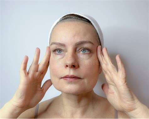 Portrait Of A Mature Woman With A Bandage On Her Head And Hands Near Her Face Stock Image