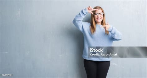 웃 고 행복 한 얼굴로 손가락과 손으로 만드는 프레임 안경을 쓰고 회색 그런 지 벽에 젊은 성인 여자 창의력과 사진 개념입니다 가을에 대한 스톡 사진 및 기타 이미지