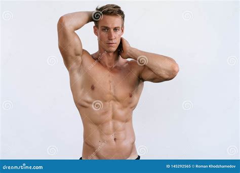 Сексуальный атлетический человек с нагим торсом на белой предпосылке Портрет моды Sporty