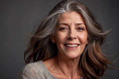 Portrait Of Smiling Beautiful Old Woman With Gray Long Hair In Dynamic Motion On Grey Background