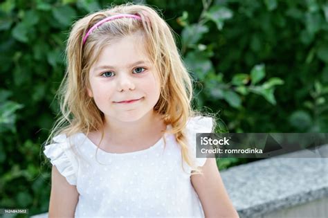 야외에서 행복한 웃는 유아 소녀의 초상화 금발 머리를 가진 어린 아이가 카메라를 보고 미소짓고 있습니다 행복한 건강한 아이는 야외 활동과 놀이를 즐길 수 있습니다 4 5세에