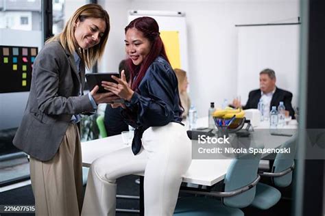 현대적인 사무실 환경에서 기업 회의 중 전자 장치로 협업하는 두 명의 전문직 여성 25 29세에 대한 스톡 사진 및 기타 이미지 25 29세 40 44세 60 64세