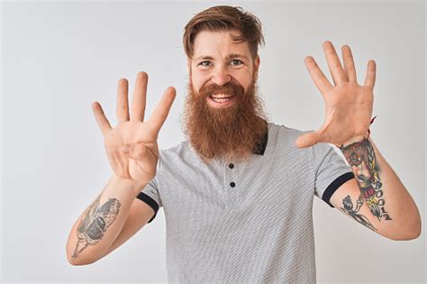 젊은 빨간 머리 아이리쉬 남자 회색 폴로 위에 서 고립 된 흰색 배경 표시 하 고 자신감과 행복 미소 동안 손가락 번호 9를 가리키는 가리키기에 대한 스톡 사진 및 기타