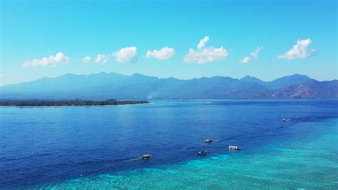 Premium 스톡 영상 푸른 바다와 청록색 석호가 있는 인도네시아 열대 해안선의 평화로운 관문 밝은 푸른 하늘을 배경으로