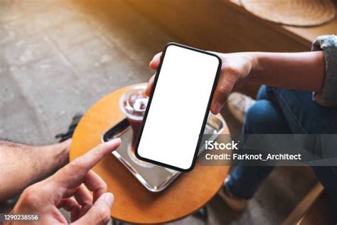 빈 데스크톱 화면이있는 흰색 휴대 전화를 들고 표시하는 동안 여자를 손가락으로 가리키는 남자 가득 찬에 대한 스톡 사진 및 기타 이미지 Istock