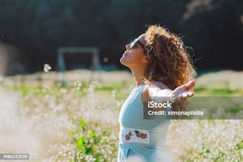 혼자 야외 레저 활동을 즐기는 한 명의 자유로운 여성이 팔을 벌리고 자연을 껴안고 있습니다 사람과 환경의 개념입니다 여행 및 자연 공원 목적지 여름과 레저를 좋아하는 사람들