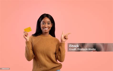 핑크 스튜디오 배경에 빈 공간을 옆으로 가리키는 신용 카드와 행복한 흑인 여자 스튜디오 촬영에 대한 스톡 사진 및 기타 이미지 스튜디오 촬영 신용 카드 쥠 Istock