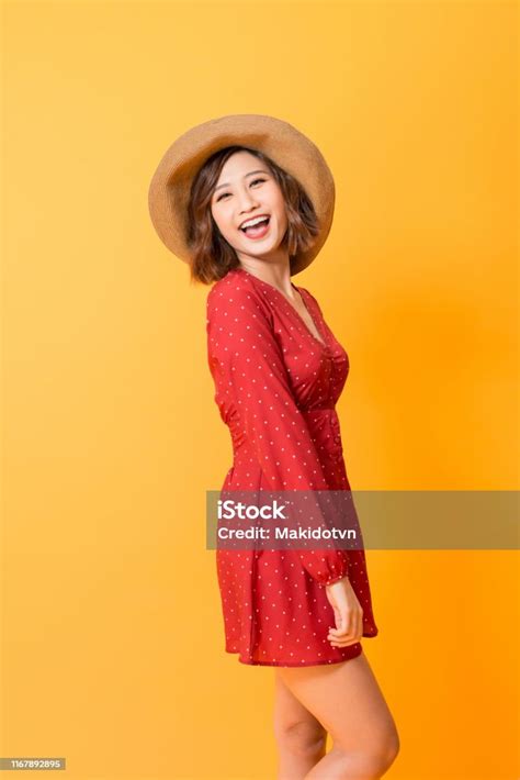 빨간 드레스와 밀짚 모자를 입고 오렌지 색 배경을 가진 행복한 활기찬 아시아 여성의 스튜디오 샷 행복에 대한 스톡 사진 및 기타 이미지 Istock