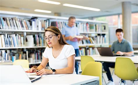 노트북으로 대학 도서관에서 공부하는 자신감있는 학생 소녀는 카피 북에 중요한 시놉시스를 씁니다 18 19세에 대한 스톡 사진 및 기타 이미지 Istock