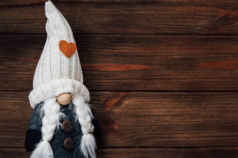니트 모자를 쓰고 아늑한 의상을 입은 수제 난쟁이 요정 인형이 소박한 나무 배경에 전시되어 있습니다 개성 개념에 대한 스톡 사진 및 기타 이미지 Istock