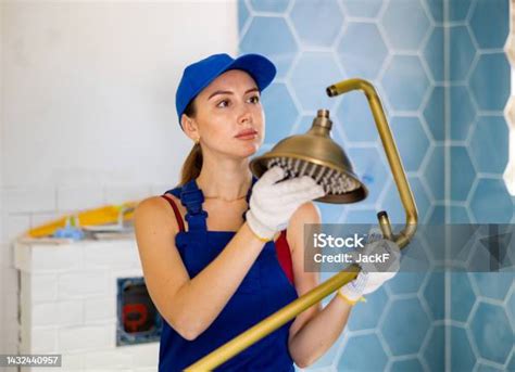 샤워 헤드를 들고 욕실에서 일하는 작업복을 입은 젊은 여성 건축업자 연관공에 대한 스톡 사진 및 기타 이미지 연관공 20 24세 30 34세 Istock