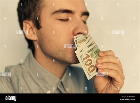 Man Sniffing Dollars The Sweet Smell Of Money Young Guy Sniffing 500 Dollar Earned Money