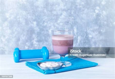 우유와 검은 건포도와 초콜릿 단백질 쉐이크 의 유리 L 배경에서 카르니틴과 파란색 아령 스포츠 영양 나무 배경입니다 공간을 복사합니다 0명에 대한 스톡 사진 및 기타 이미지