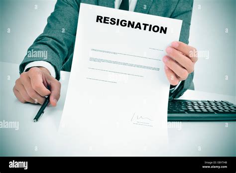 A Man In Suit In His Desk Showing A Figured Signed Resignation Document