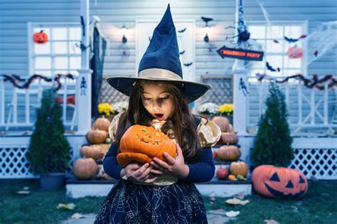 할로윈 트릭 또는 치료에 잭 오 랜턴 호박을 들고 마녀 의상을 입은 어린 소녀 사탕주면 안 잡아먹지에 대한 스톡 사진 및 기타 이미지 사탕주면 안 잡아먹지 소녀 차려