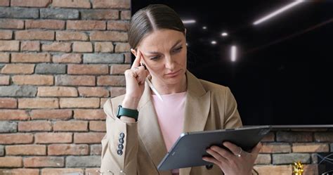 현대적인 사무실의 젊은 여성 인테리어 디자이너는 태블릿에서 프로젝트 세부 사항을 검토하는 데 중점을 둡니다 재료 샘플과 색상 팔레트를 분석하면서 창의적인 계획과 협업을