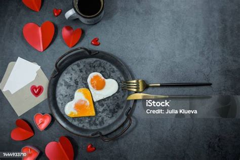 빈티지 팬에 수제 계란 후라이 커피 머그잔 하트 어두운 배경에 세련된 식기류 심장 모양의 계란 위에서 본 모습 텍스트 공간을 복사합니다 단호하게 목신에 대한 스톡 사진 및