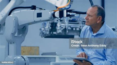 기계 태블릿 테스트 및 엔지니어 전자 기술자 및 로봇 공학에 종사하는 사람 성숙한 남성 직원 로봇 역학 및 자동화를 점검하는 작업자의 계획 및 전문 엔지니어링 작업 55