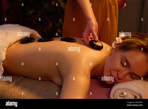 High Angle Shot Of Adorable Relaxed Woman With Plumeria In Hair Lying On Massage Table While Her