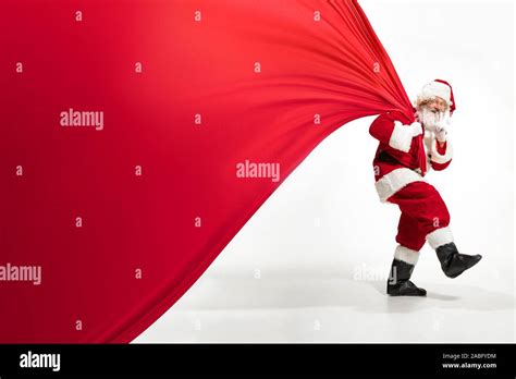 Santa Claus Pulling Huge Bag Full Of Christmas Presents Isolated On