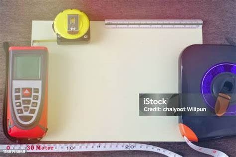 테이블 길이 측정 도구 적외선 미터 테이프 측정 통치자 테이블에 백서 아침 햇빛 정비사 작업 토지 계획을 측정에 배경 건설