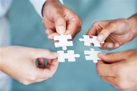 Hands Of Business People Challenge And Teamwork With Puzzle For