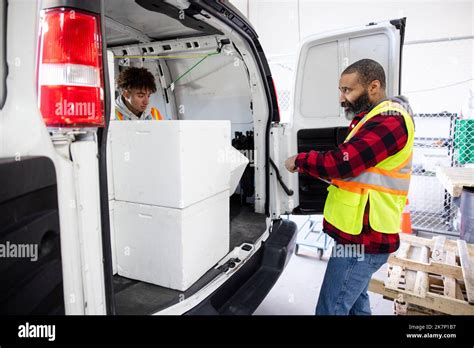 Male Warehouse Workers Loading Boxes Into Van Stock Photo Alamy