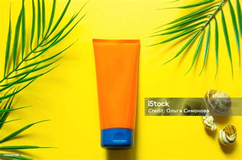 야자수 잎과 태양이있는 노란색 여름 배경에 자외선 차단제 튜브 태닝 제 피부 보호 바다 여행 해변에서의 휴가 자외선 보호 Spf 필터 플랫 레이 복사 공간 관광 리조트에