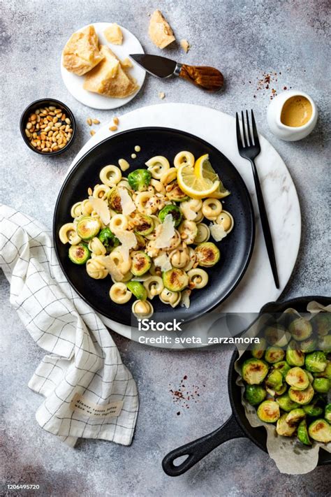 구운 브뤼셀 콩나물 소나무 견과류 파마산 치즈 레몬 소스 붉은 칠리 플레이크를 곁들인 신선한 홈메이드 이탈리아 파스타 카펠레티
