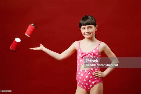 두 개의 종이 컵스튜디오에서 포즈를 취하는 수영복을 입은 매력적인 어린 소녀의 고립 된 샷 스튜디오에서 예쁜 여성 아이 귀여운에