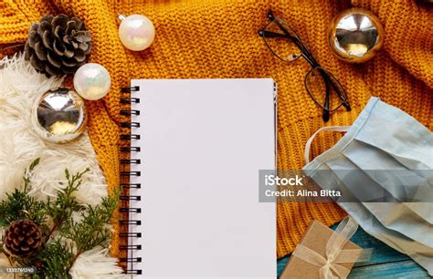 겨울 또는 가을 아늑한 평지 구성 따뜻한 니트 스웨터 크리스마스 장난감 의료 마스크 컵 및 빈 종이 나선형 노트북 카드와 선물 모형 책상에 대한 스톡 사진 및 기타 이미지