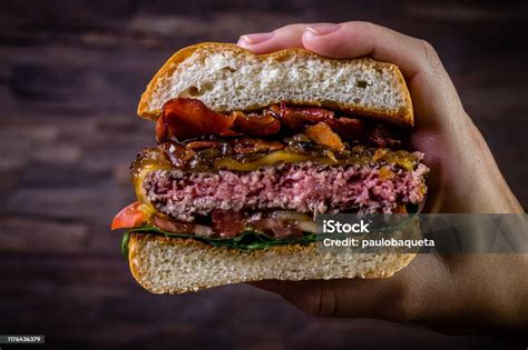 치즈 베이컨 로켓 잎을 곁들인 갈라진 수제 소고기 버거를 들고 있는 손 고기에 대한 스톡 사진 및 기타 이미지 고기 굽기