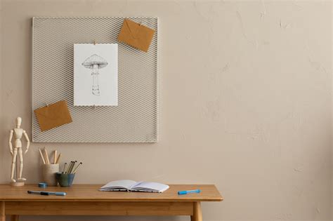 모형 포스터 프레임 복사 공간 나무 책상 책 펜이 달린 컵 갈색 벽 조각품 및 개인 액세서리가있는 아늑한 사무실 인테리어의 인테리어 디자인 가정 장식 템플렛 벽에 대한 스톡