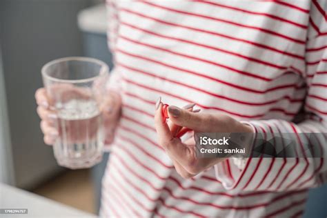 약을 복용하는 여성 여성의 손에 있는 물 한 잔과 빨간 알약의 클로즈업 알약에 대한 스톡 사진 및 기타 이미지 알약 여자 쥠 Istock
