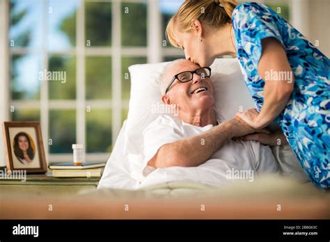 Friendly Young Rest Home Nurse Cheers Up Her Elderly Male Patient With
