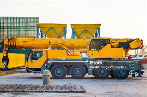 노란색 바퀴 달린 트럭 크레인이 항구에 서 있습니다 무거운 바퀴 달린 적재 장비 이동식 크레인에 대한 스톡 사진 및 기타 이미지 이동식 크레인 화물 컨테이너 건설