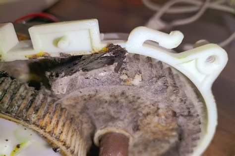 윤활유의 노화 부하 증가 및 모터 가열의 결과로 인해 고장난 전기 고기 분쇄기의 플라스틱 기어로 구성된 분해 된 메커니즘 0명에