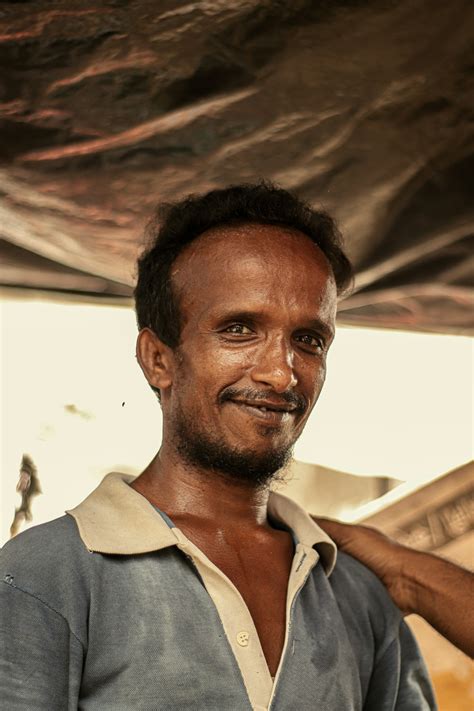 Un Homme Debout Sous Une Bâche Avec Un Sourire Sur Son Visage Photo