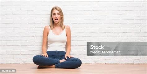 섹시 한 표정 명랑 하 고 행복 한 얼굴을 카메라 보고 윙크 하는 아름 다운 젊은 여 자가 집에서 바닥에 앉아 관능에 대한 스톡 사진 및 기타 이미지 Istock